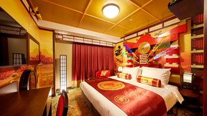 Quarto de hotel com uma cama grande, uma mesa de jantar e uma televisão.