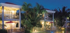 Um hotel com vários andares, varandas, área de estar externa e piscina.