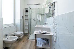Quarto Deluxe, 1 cama individual extragrande | Casa de banho | Um polibã, um chuveiro fixo, artigos de higiene pessoal grátis 