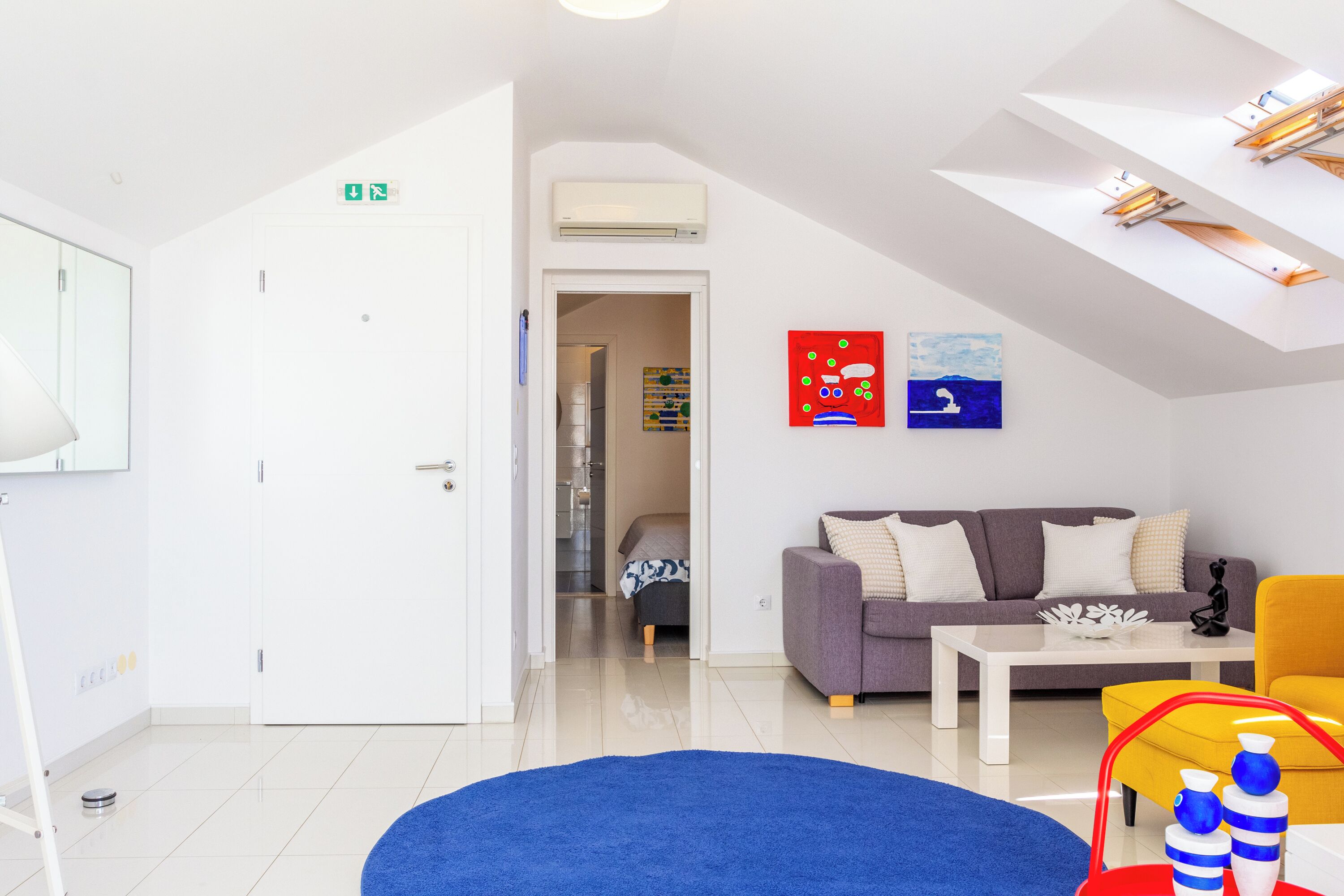 Uma sala de estar moderna com um sofá, mesa de centro e um tapete azul.