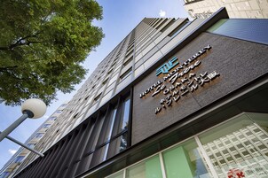 Placa de hotel com o nome 'Hotel Monte Carlo' e a inscrição 'Japan Tax-free Shopping'.