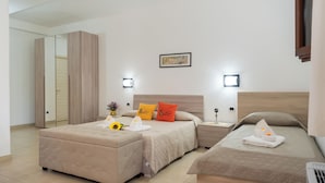 Quarto de hotel com duas camas, um guarda-roupa e um quadro na parede.