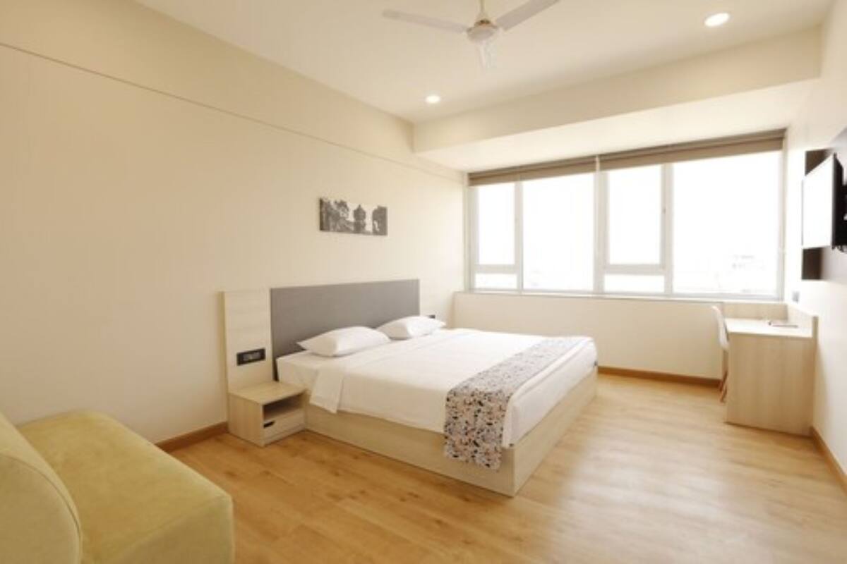 Quarto moderno com cama, mesa de cabeceira e janela.