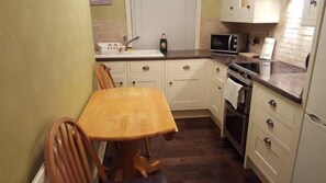 Apartamento, 2 quartos | Cozinha privada | Um frigorífico, um micro-ondas, um forno, uma placa de cozinha 