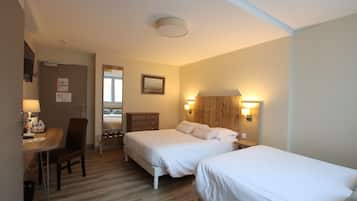 Quarto de hotel com duas camas, uma escrivaninha, uma cadeira e uma cômoda de madeira.