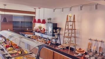 Uma área de buffet com diversas opções de comida, um canto para café e uma estante decorativa em formato de escada.
