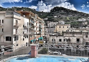 Zona residencial com edifícios altos, varandas e um cenário montanhoso ao fundo.