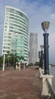 Um calçadão à beira-mar com edifícios modernos, um poste de luz e um passeio pavimentado.