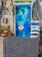 Piscina com um mural de uma sereia e uma mulher de biquíni.