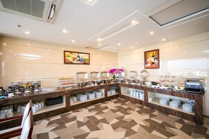 Disposição de buffet com várias estações de serviço, piso estampado e obras de arte nas paredes.
