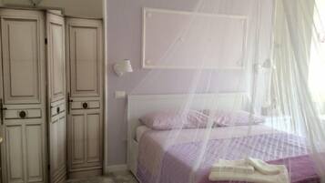 Quarto com cama, guarda-roupa e mesa de cabeceira.
