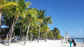 Perto da praia, praia de areia branca, espreguiçadeiras 