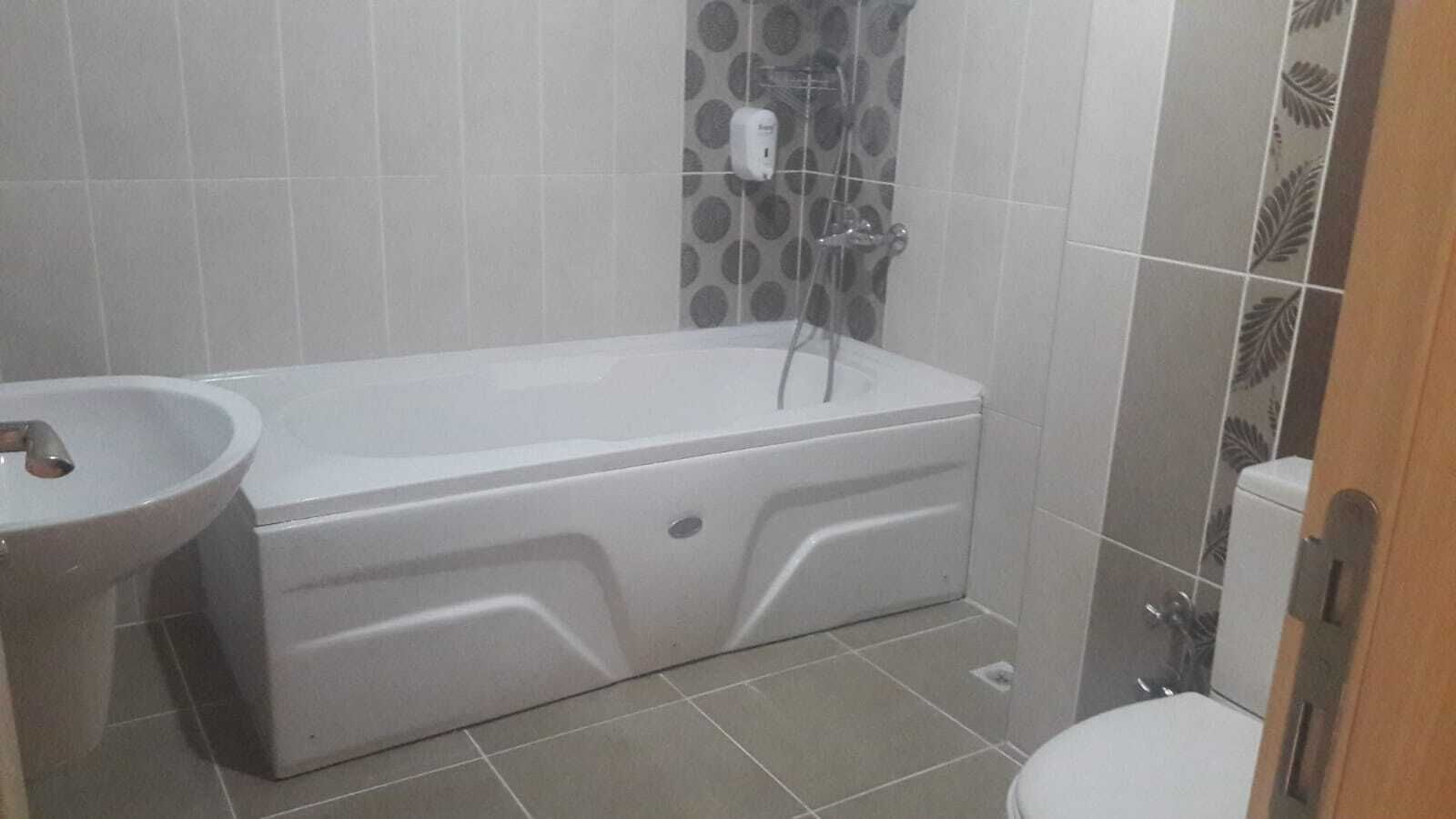 Um banheiro com banheira, pia e vaso sanitário.