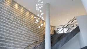 Um interior moderno com parede de tijolos, escada e luminárias esféricas penduradas.