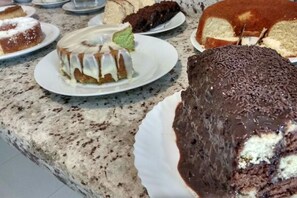 Diversos bolos sobre um balcão de mármore.