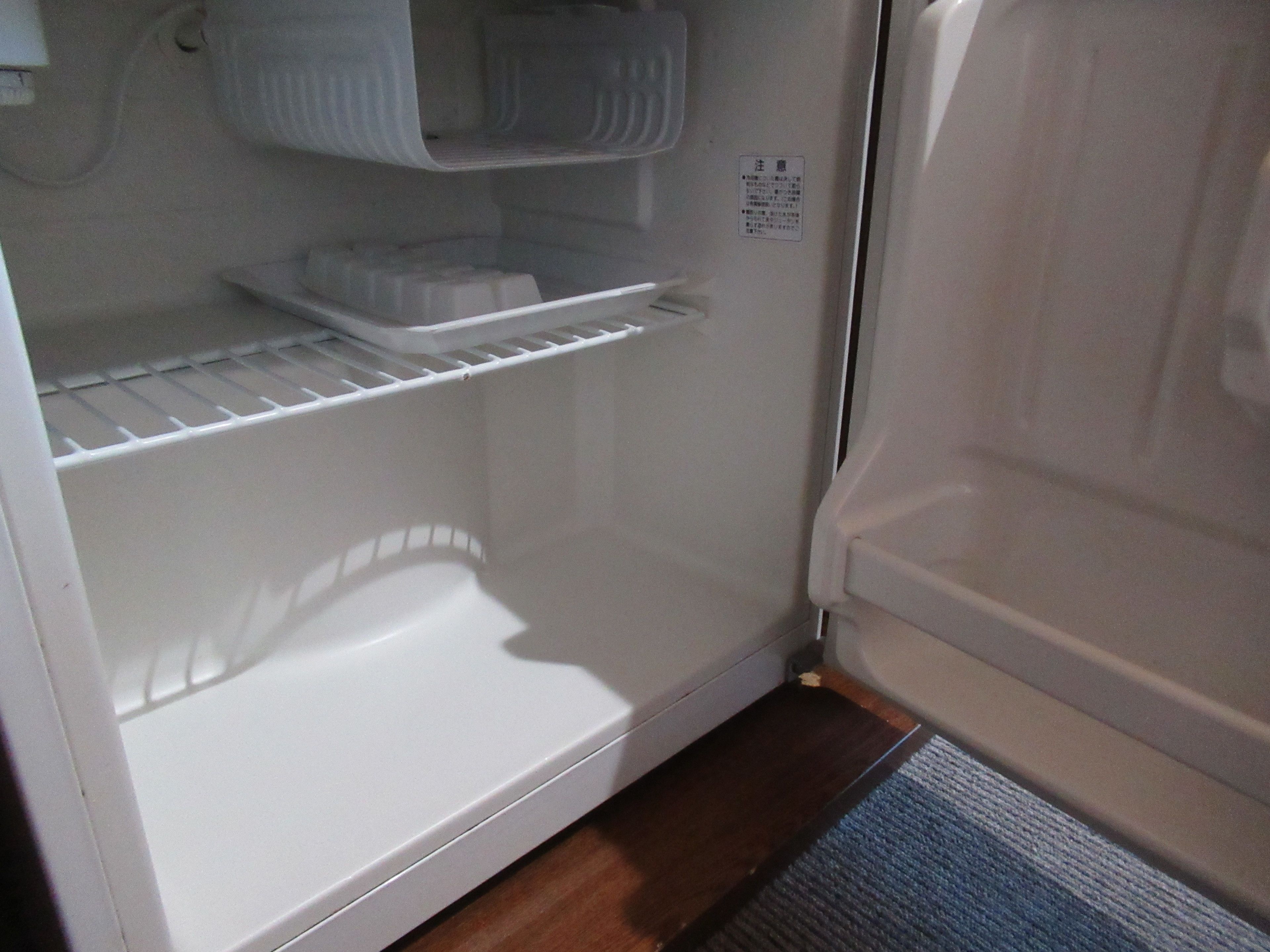 Geladeira vazia com prateleiras e compartimento congelador.