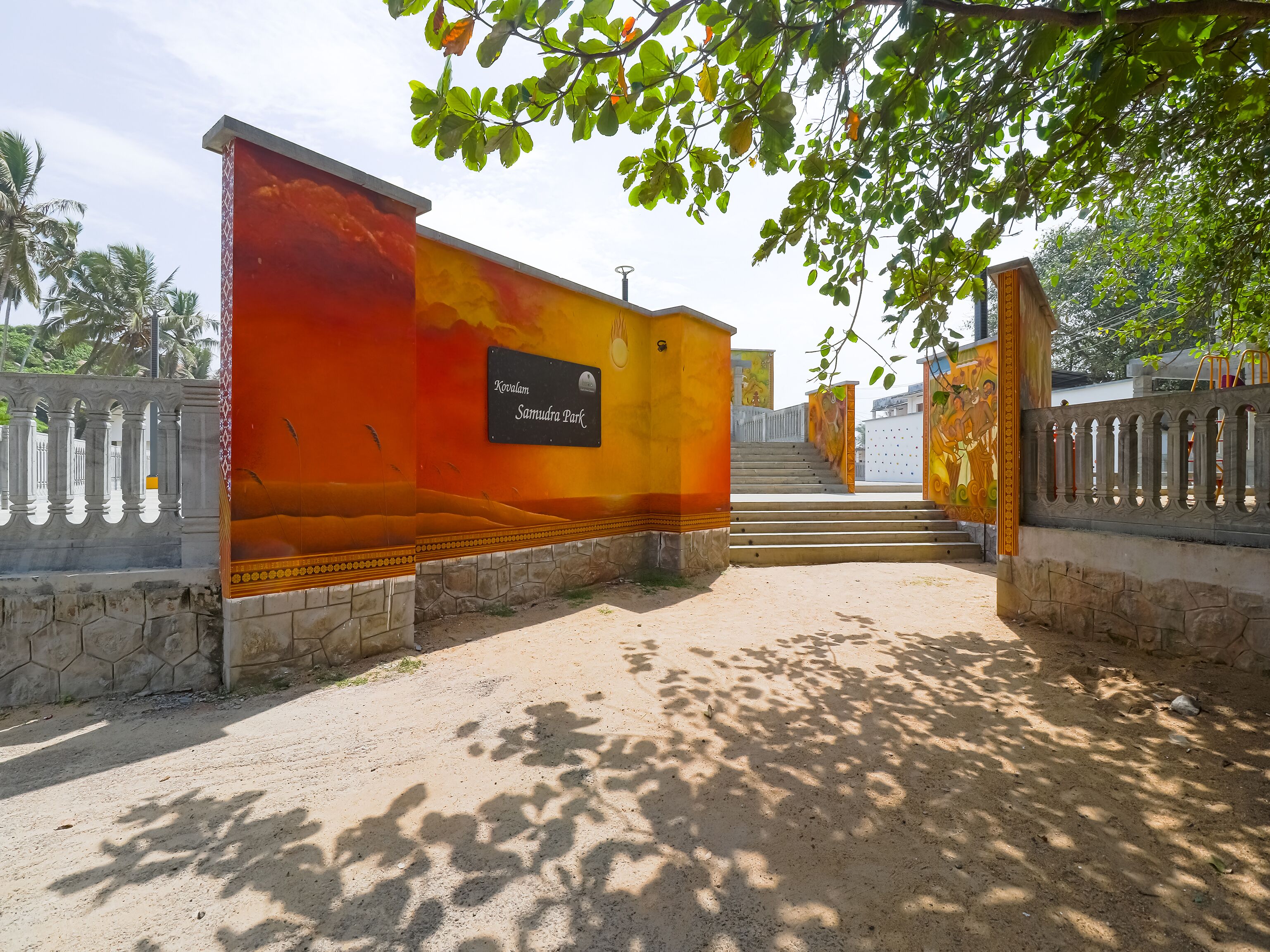 Escadaria que leva a um parque, com uma placa indicando "Kovalam Samudra Park".