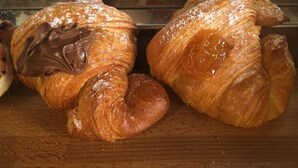 Dois croissants com chocolate sobre uma superfície de madeira.