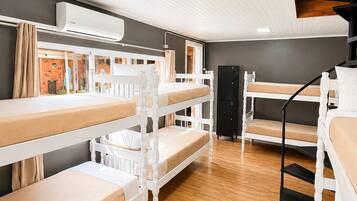 Quarto com beliche, ventilador de teto, ar condicionado e vista para o exterior.