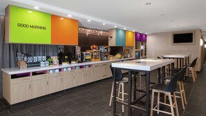 Cozinha moderna com bancada, banquetes e um letreiro que diz 'GOOD MORNING'.