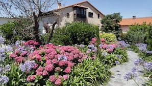 Uma casa com um caminho de jardim que leva a um edifício com telhado de telhas.