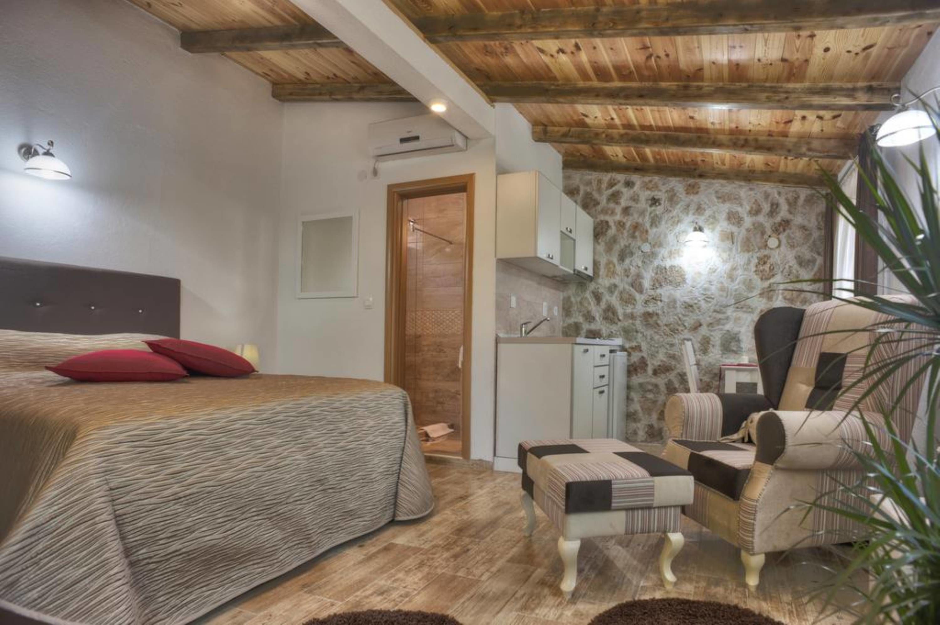 Um quarto com uma cama, uma cadeira, uma mesinha e um armário.