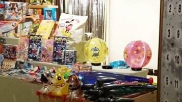 Exposição de brinquedos e jogos, incluindo um carrinho e um globo terrestre, em um quarto com um calendário na parede.