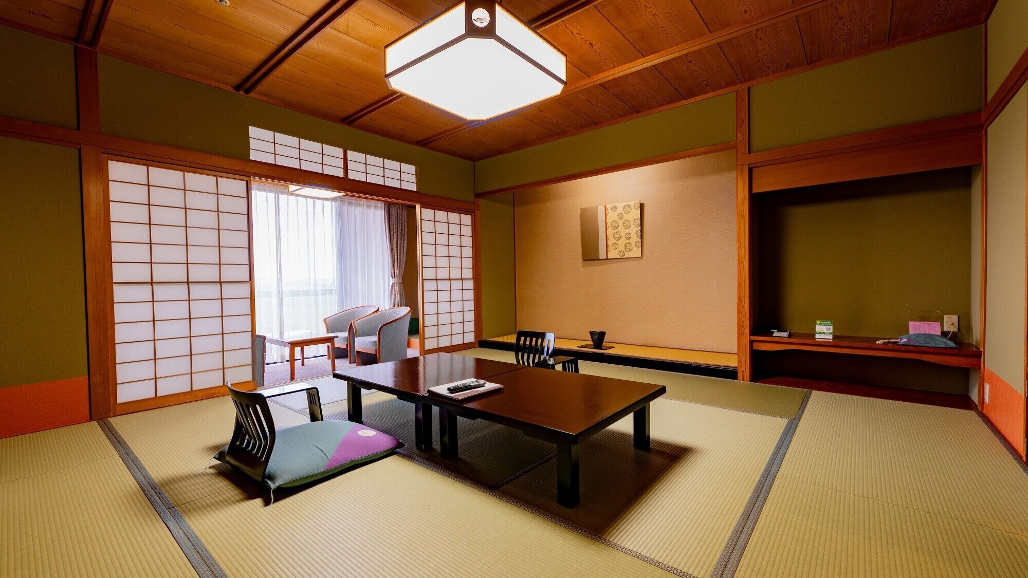 Um quarto em estilo japonês tradicional, com tatames, uma mesa baixa, cadeiras e uma porta deslizante.