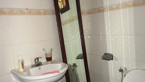 Casa de banho com lavatório, sanita e espelho.