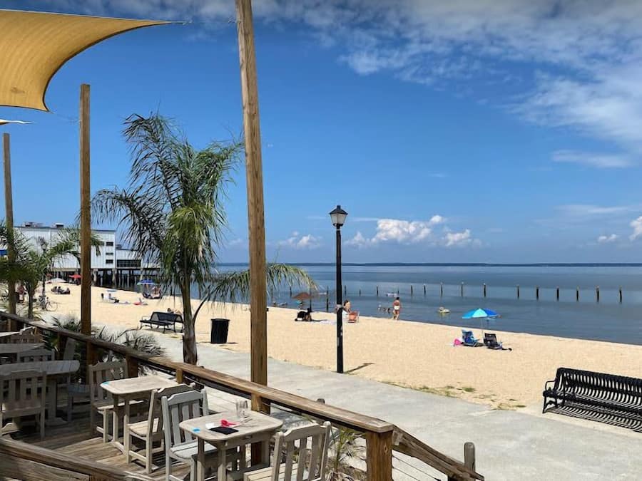 Perto da praia, areia branca, guarda-sóis, toalhas de praia