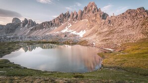 Paisagem montanhosa com um lago límpido refletindo os picos.