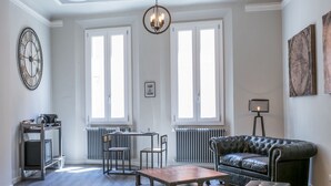Sala de estar com sofá de couro, mesa de centro, TV em um móvel e radiador.