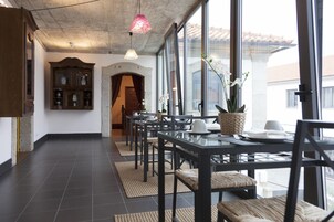 Uma sala de jantar com uma mesa comprida, cadeiras e um vaso de planta.