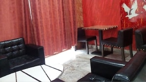Quarto com parede vermelha, um mural e uma mesa com cadeiras.