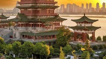 Uma pagoda tradicional em vários níveis, com um horizonte urbano ao fundo.