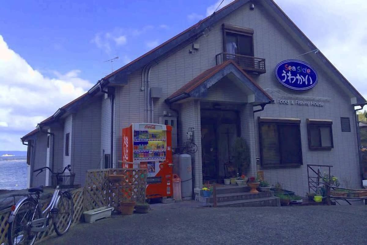 Um edifício com uma placa que diz 'Seaside' e 'Food & Fishing House'.