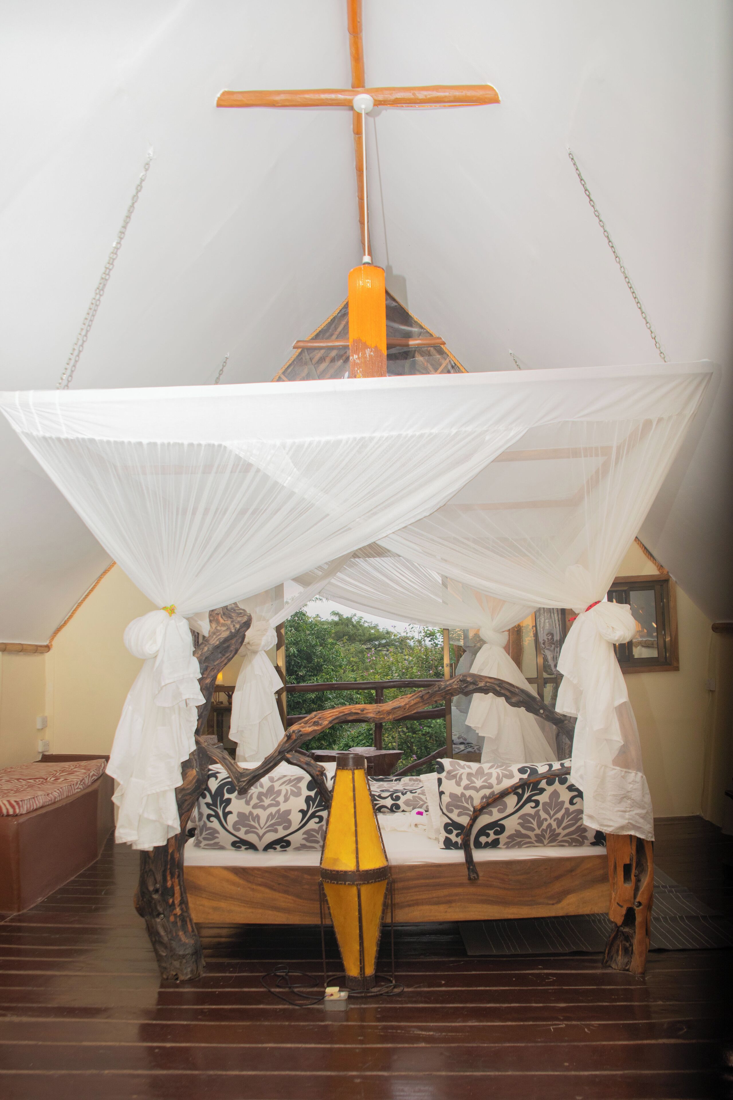 Uma cama com dossel, cabeceira de madeira e almofada decorativa.
