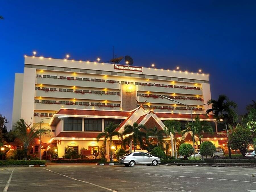 Hotel de vários andares com entrada destacada e área de estacionamento à frente.