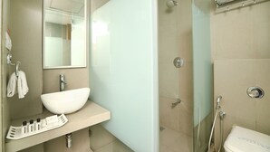 Uma casa de banho moderna com uma grande pia branca, cabine de duche em vidro e sanita.