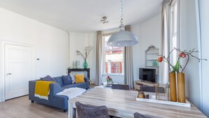 Uma sala de estar moderna com sofá, mesa de centro e área de jantar.