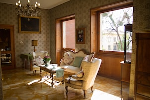 Uma sala de estar aconchegante com sofá, poltrona e uma mesa com um vaso.