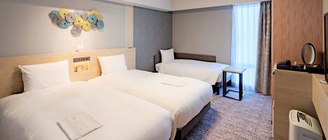 Quarto de hotel com duas camas, uma escrivaninha, um espelho e um cesto de lixo.