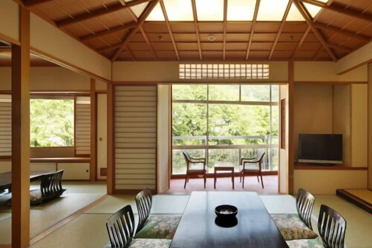 Um quarto japonês tradicional, com tatames, uma mesa baixa com almofadas e portas deslizantes.