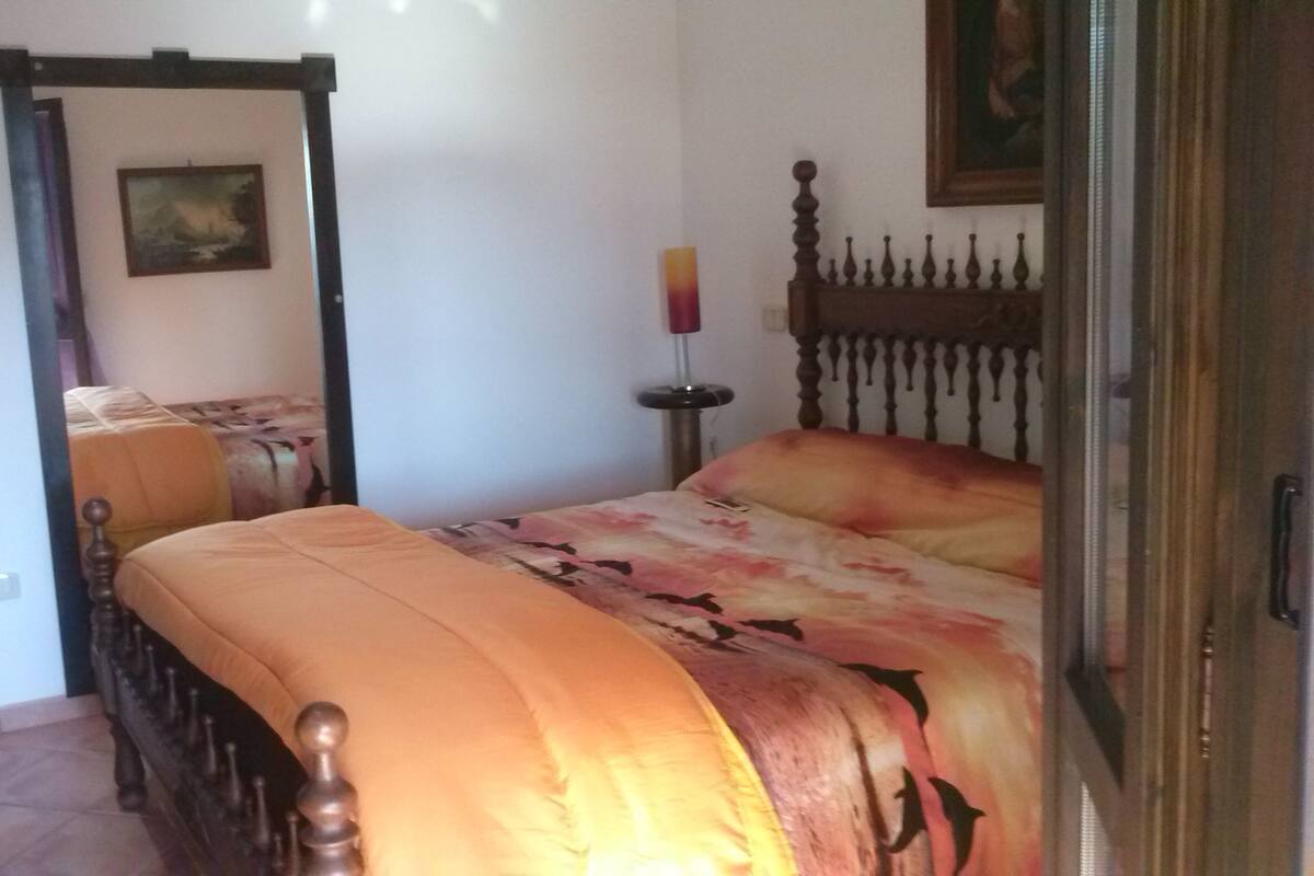 Um quarto com uma cama, uma mesa de cabeceira, um abajur e um quadro na parede.