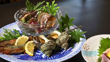 Prato com diversos frutos do mar, incluindo camarão, mexilhões e amêijoas, decorado com limão e salsa.