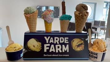 Exposição de cones e potes de sorvete na Yarde Farm, com um letreiro que diz 'Levamos o sorvete a sério'.