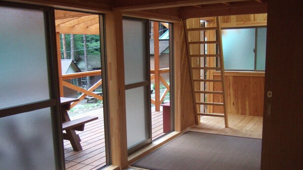 Interior de madeira com portas de vidro deslizantes para um terraço ao ar livre.