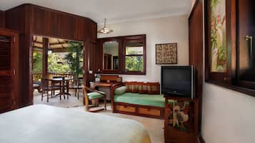 Quarto espaçoso com uma cama grande, uma escrivaninha, um sofá e uma televisão.
