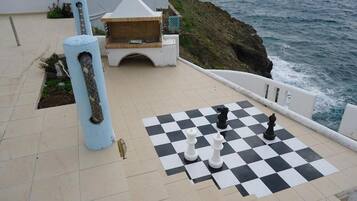 Um tabuleiro de xadrez montado em um terraço com vista para o oceano.