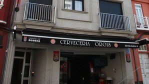 Um edifício de vários andares com uma fachada que se chama "Cerveceria Oros".